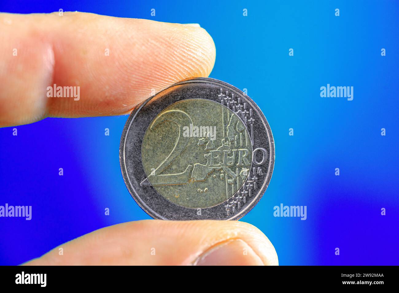 2 euro coin face held between thumb and index finger Stock Photo - Alamy