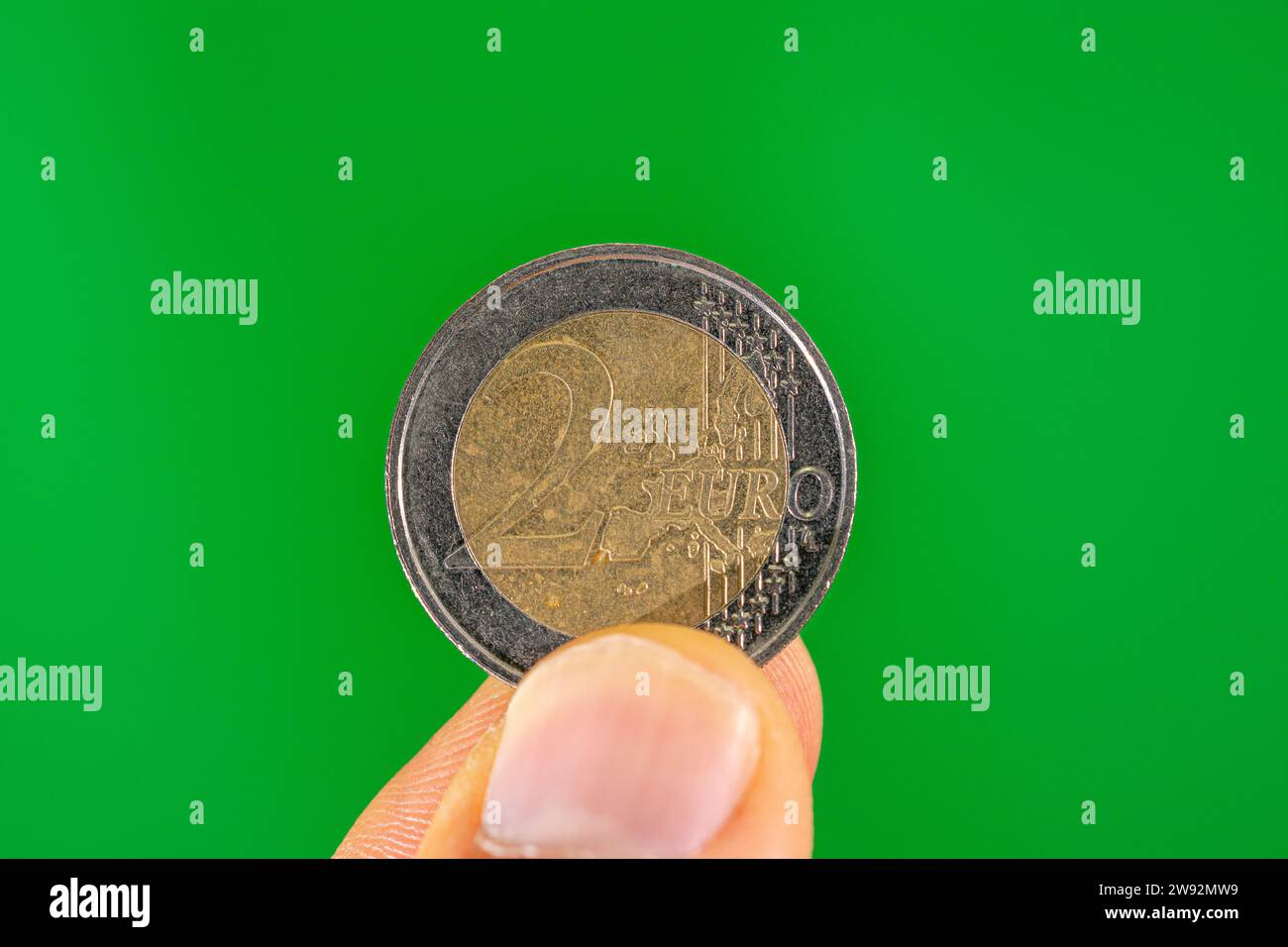 2 euro coin face held between thumb and index finger Stock Photo - Alamy