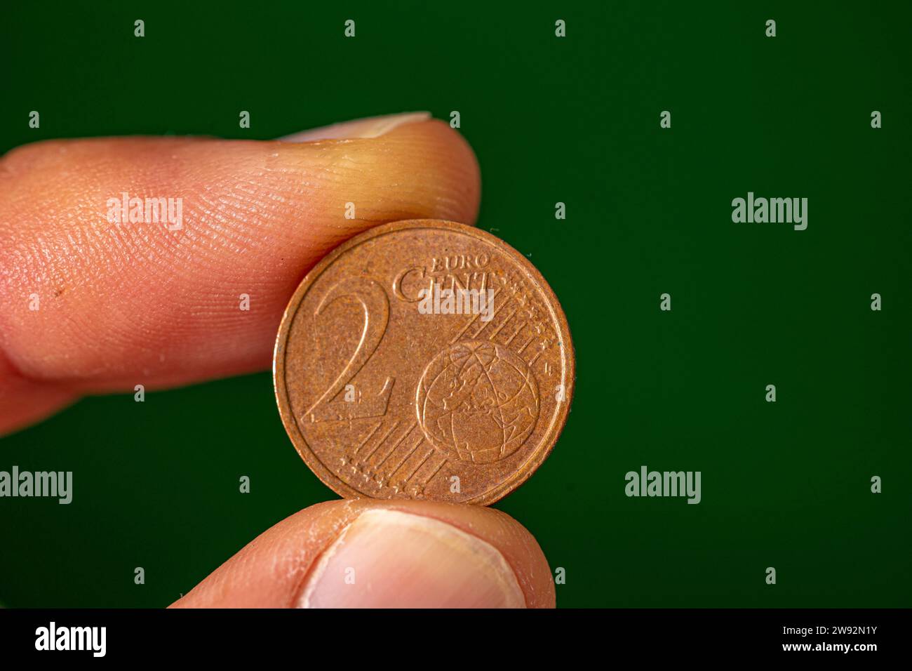 2 euro cent coin face held between thumb and index finger Stock Photo ...