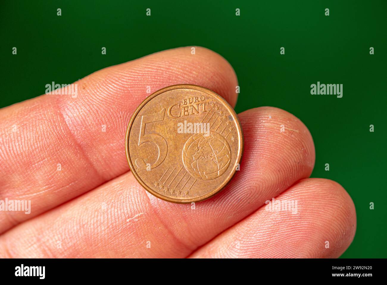 5 euro cent coin face held between thumb and index finger Stock Photo ...