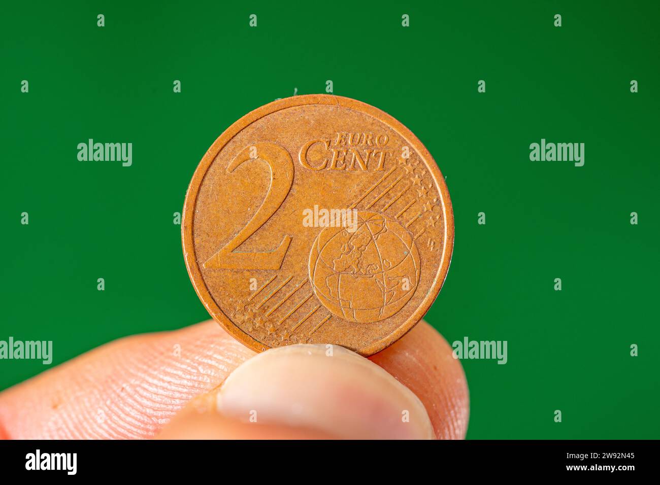 2 euro cent coin face held between thumb and index finger Stock Photo ...