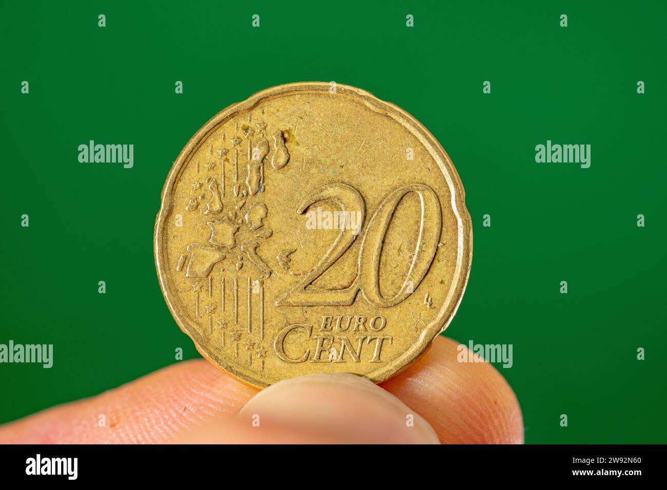 20 euro cent coin face held between thumb and index finger Stock Photo ...