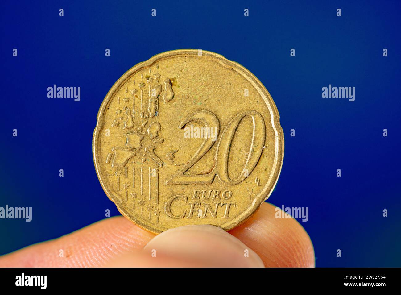 20 euro cent coin face held between thumb and index finger Stock Photo ...