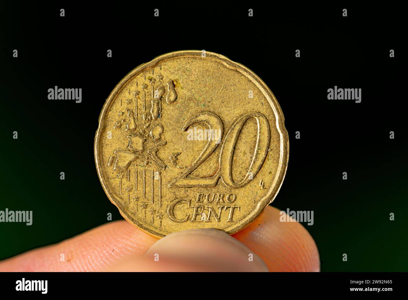 20 euro cent coin face held between thumb and index finger Stock Photo ...