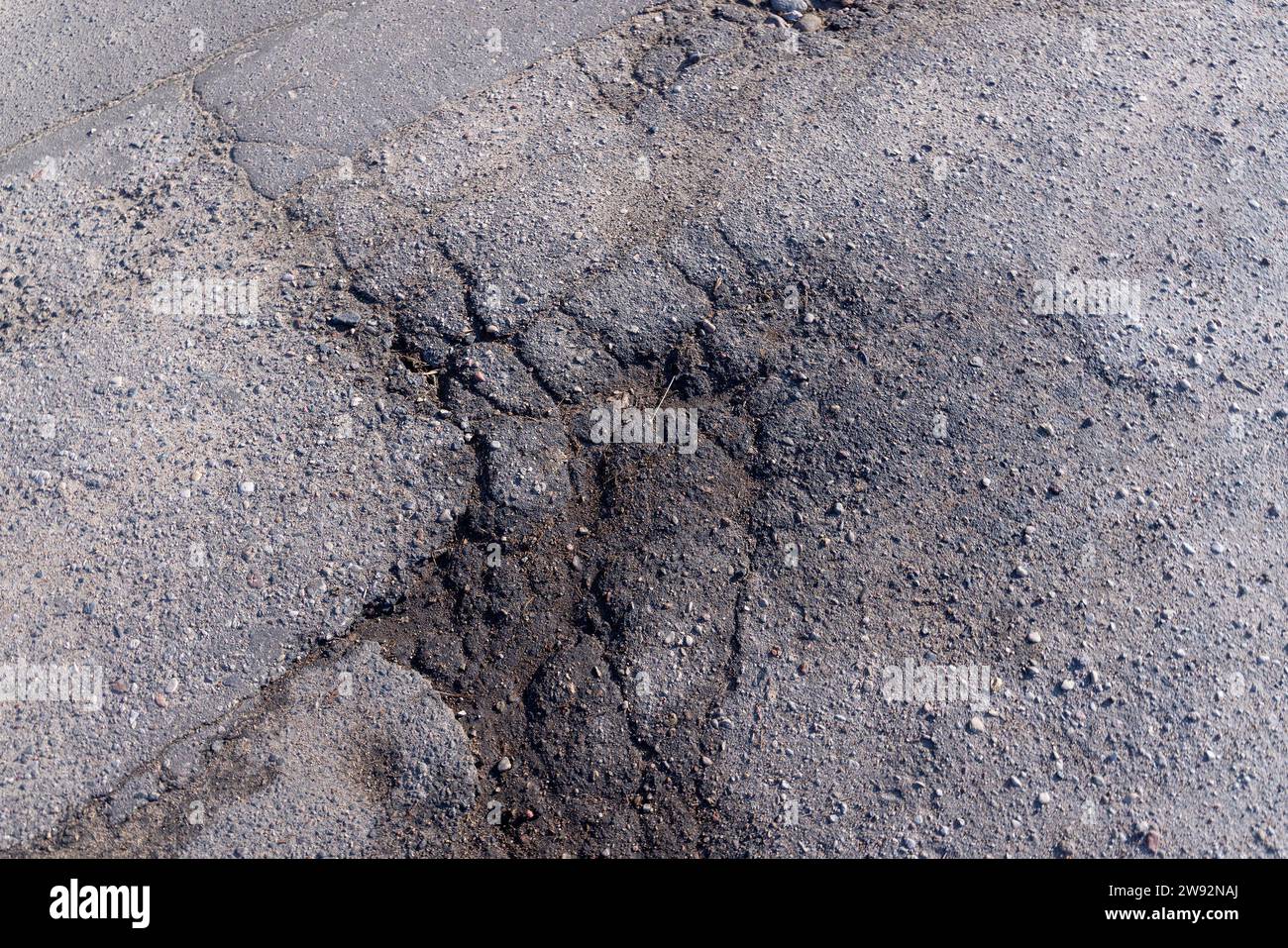 a damaged paved road with a lot of holes, a damaged road with broken ...