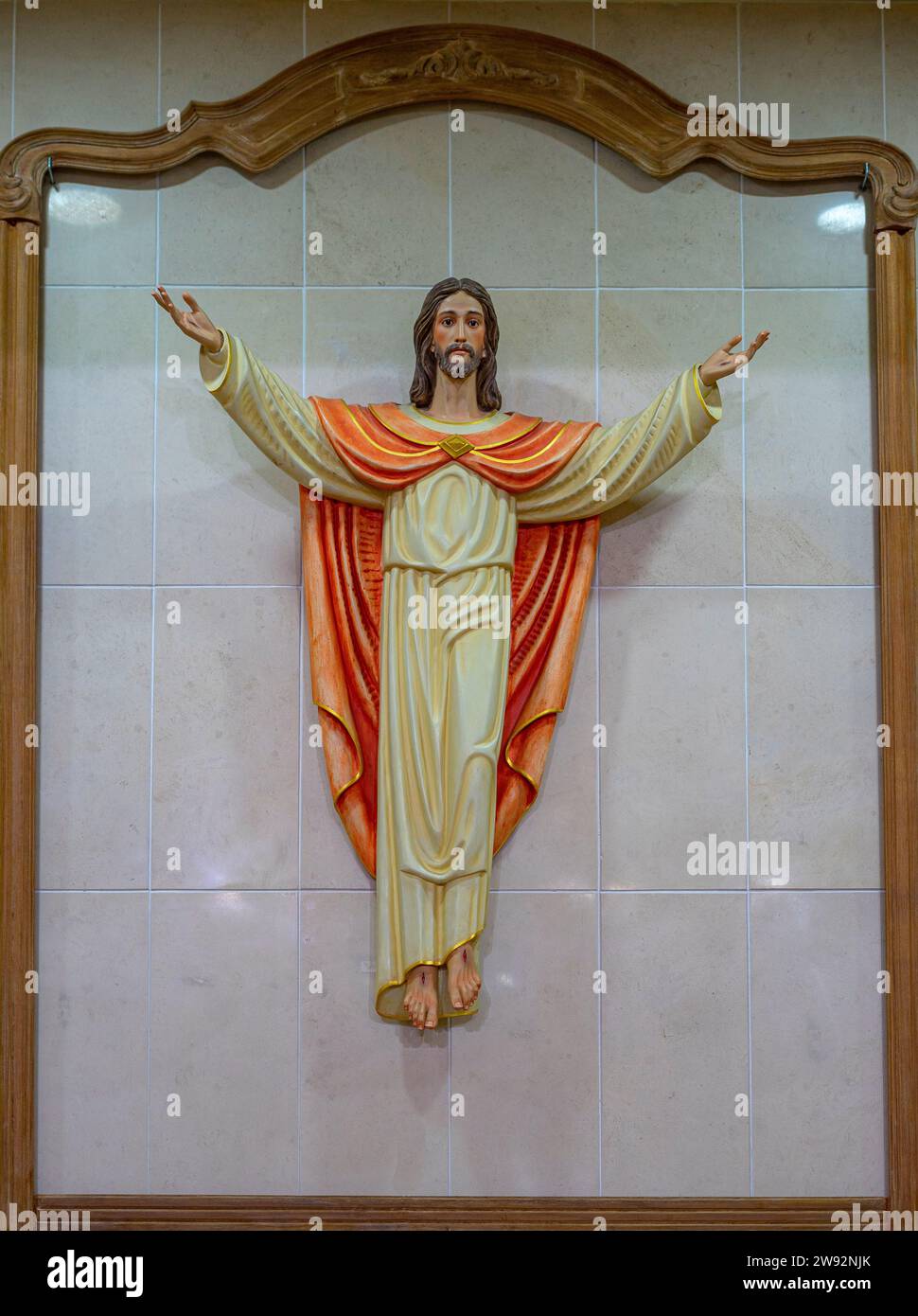 figure of jesus christ with open arms fixed to the tiled wall in a ...
