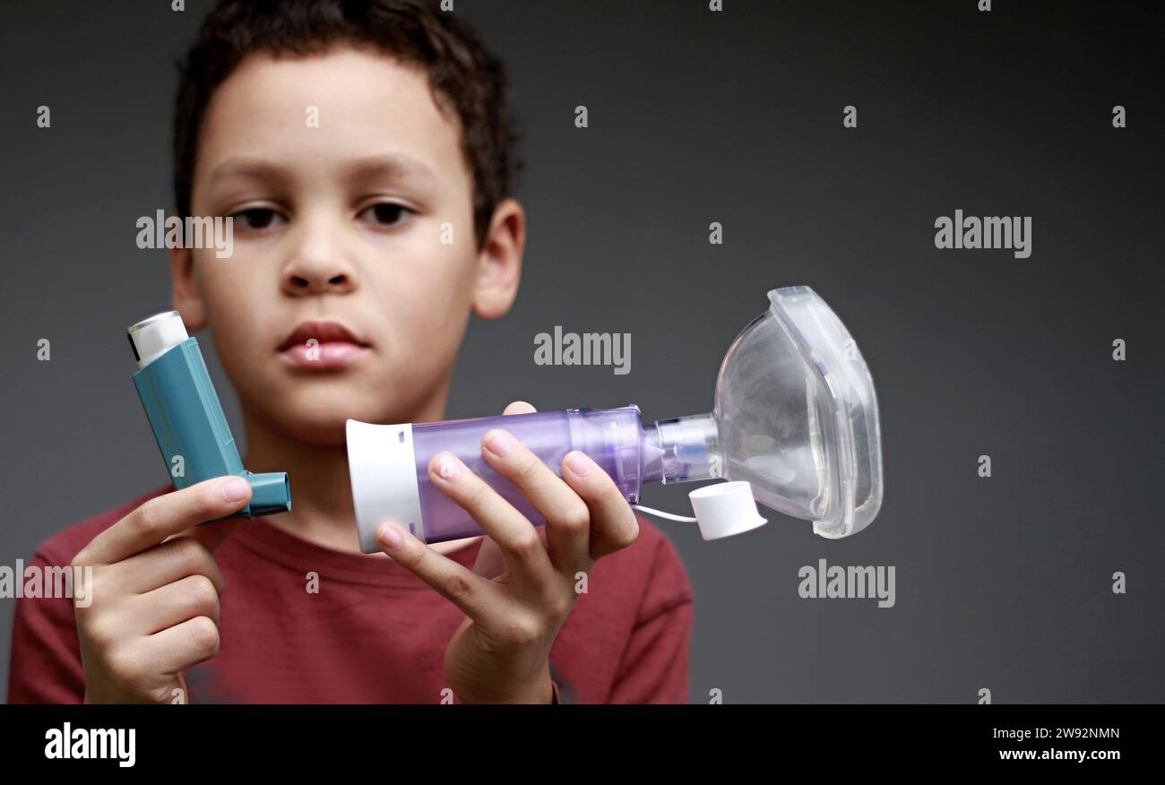 child with flu and inhaler respiratory puff on grey background with ...