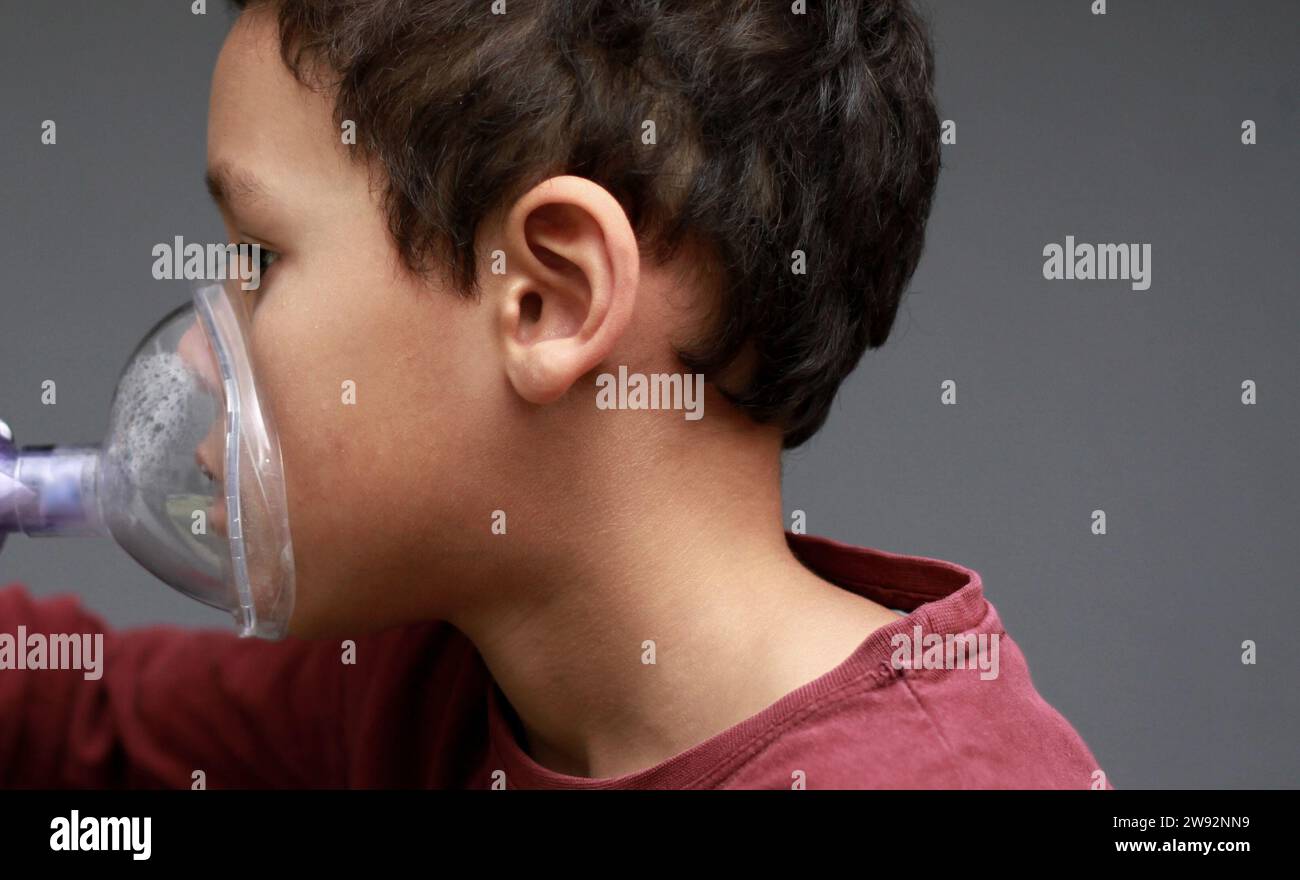 child with flu and inhaler respiratory puff on grey background with ...