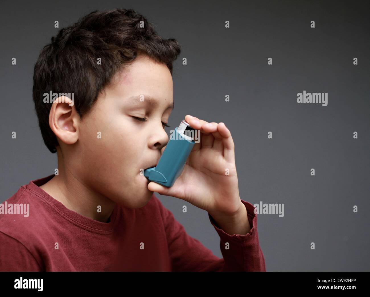 child with flu and inhaler respiratory puff on grey background with ...