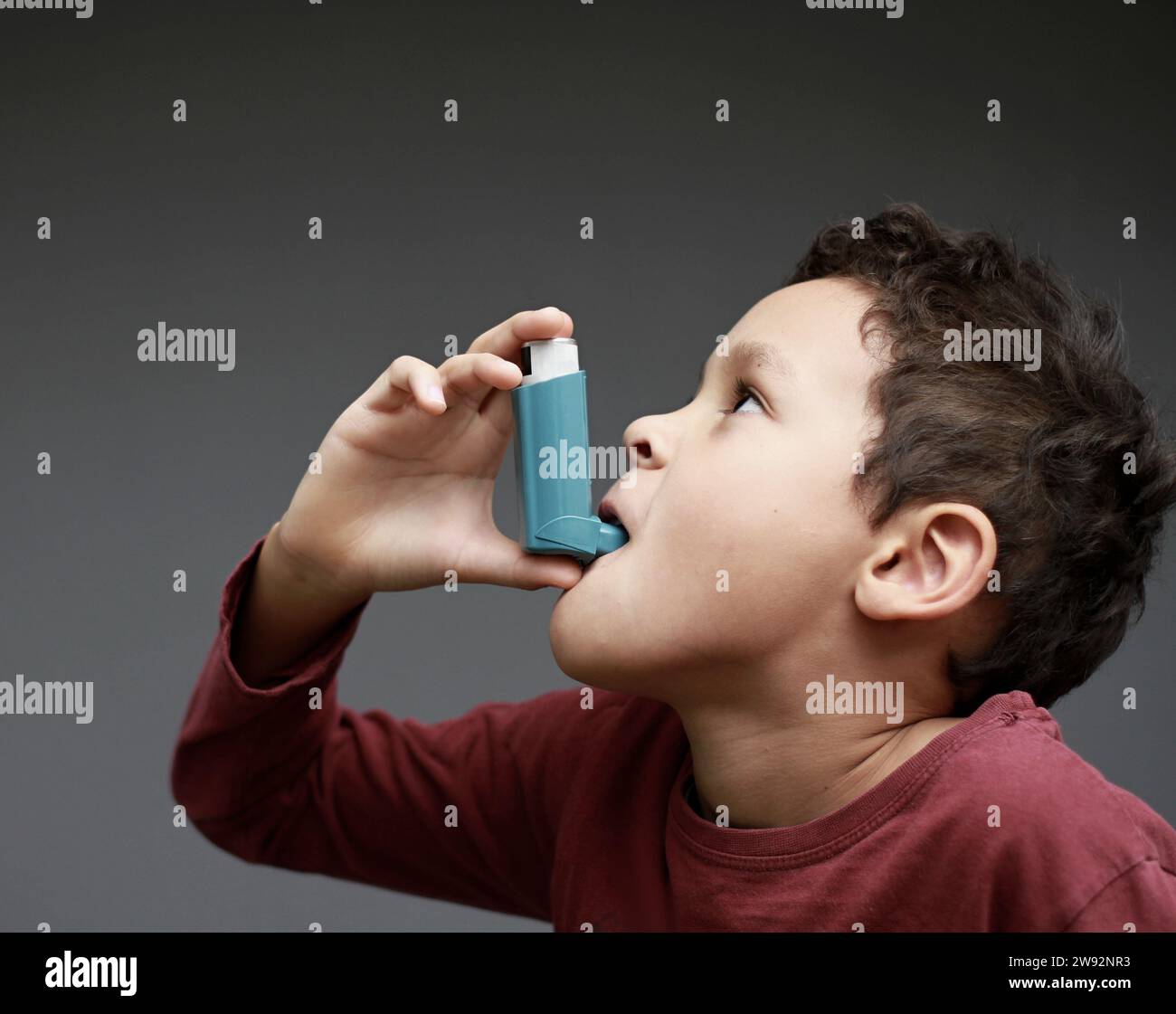 child with flu and inhaler respiratory puff on grey background with ...