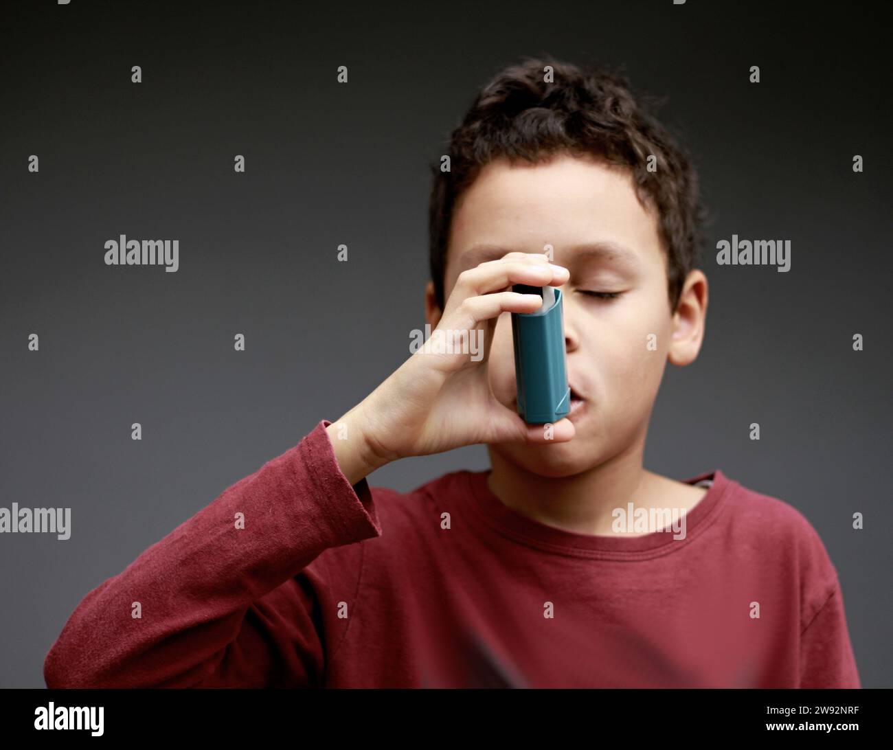 child with flu and inhaler respiratory puff on grey background with ...