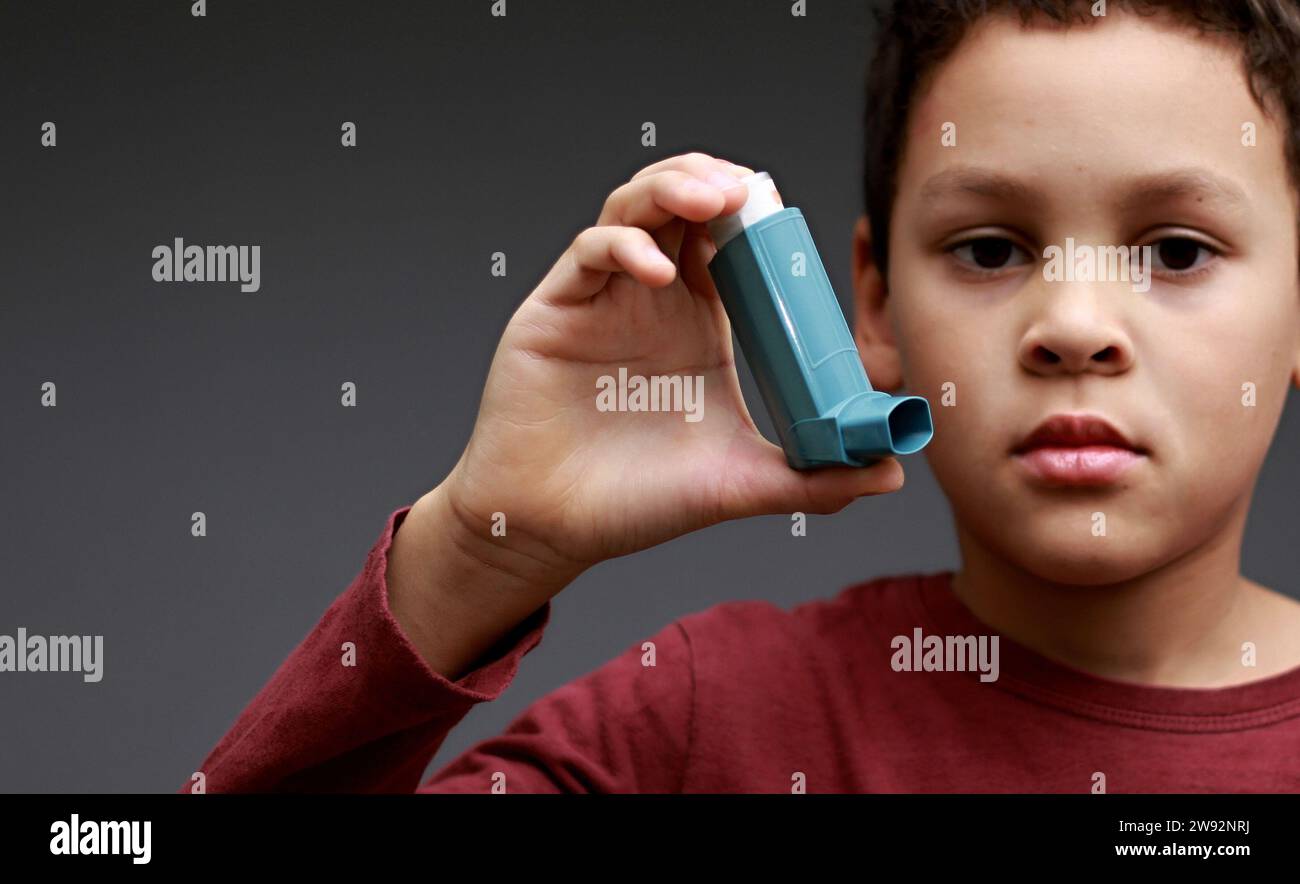 child with flu and inhaler respiratory puff on grey background with ...
