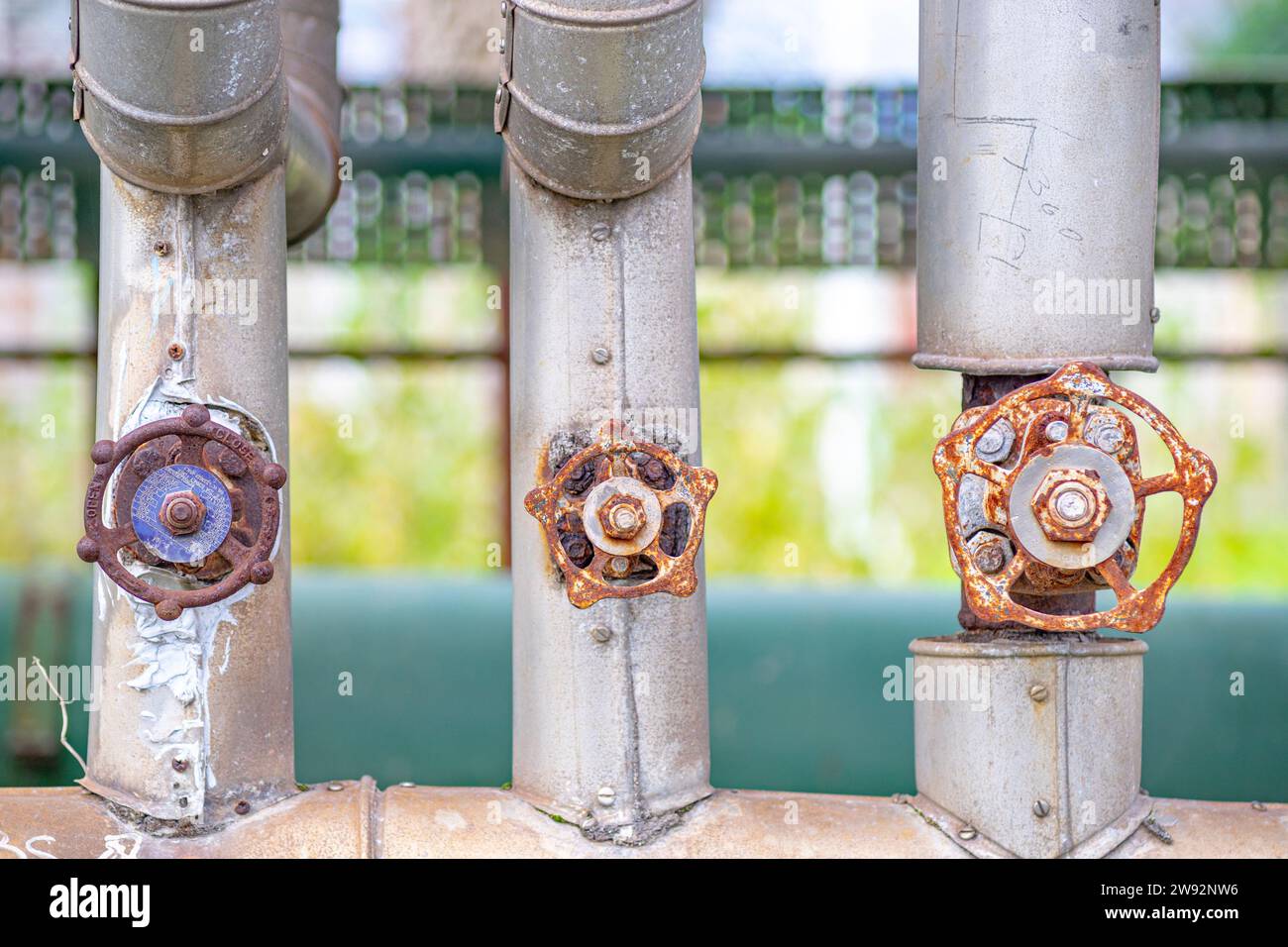 3 old and rusty faucets lined up in a chemical factory Stock Photo - Alamy