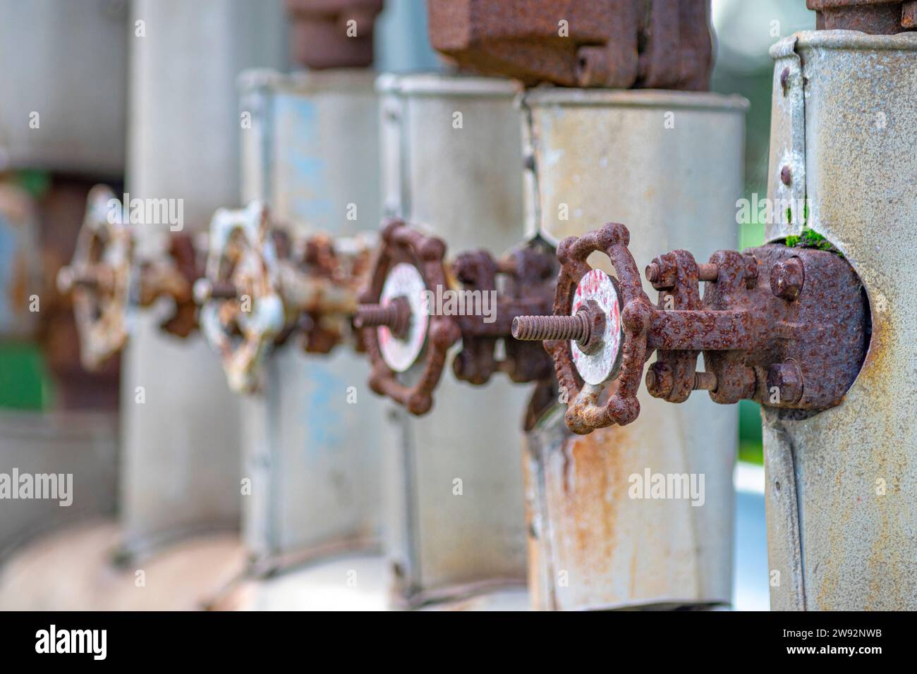 4 old and rusty faucets lined up in a chemical factory, different focus ...
