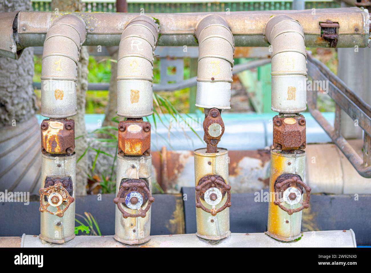 4 old and rusty faucets lined up in a chemical factory Stock Photo - Alamy