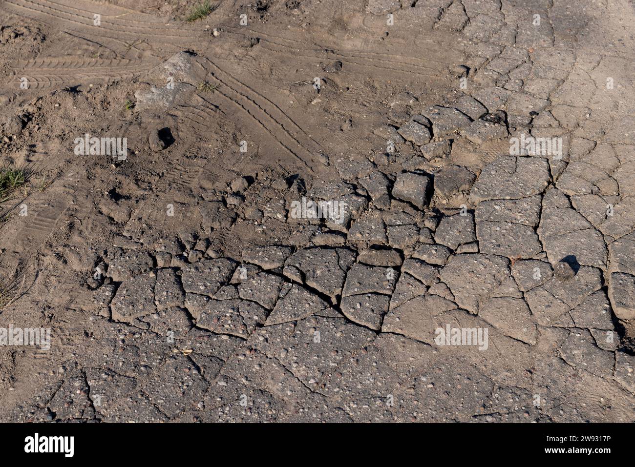 A damaged road dangerous for traffic, pits and cracks on the asphalt of ...