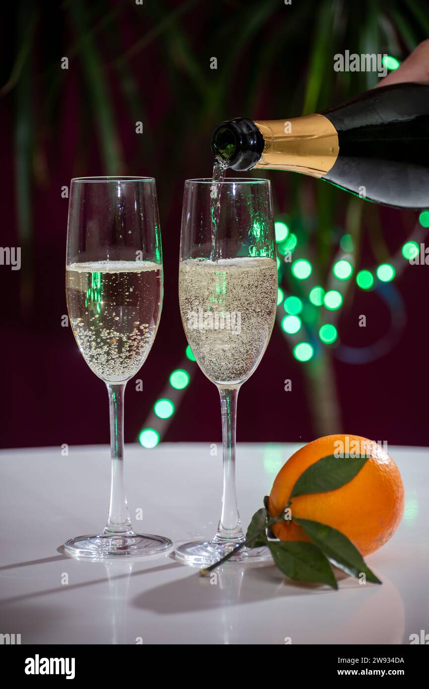 Pouring of brut champagne, cava or prosecco dry wine in glasses with ...