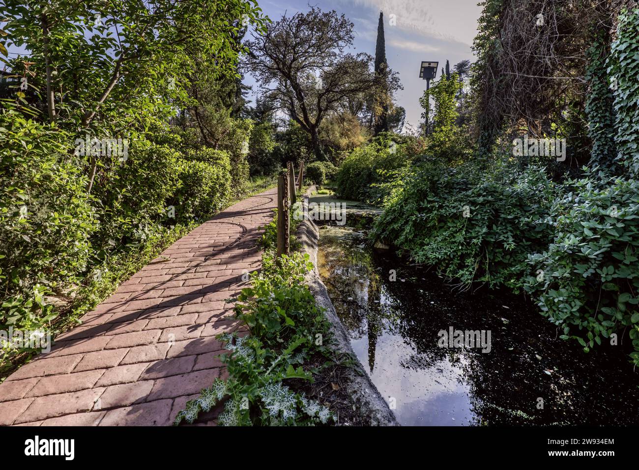 A stream of water next to a red cobblestone path within a plot Stock ...