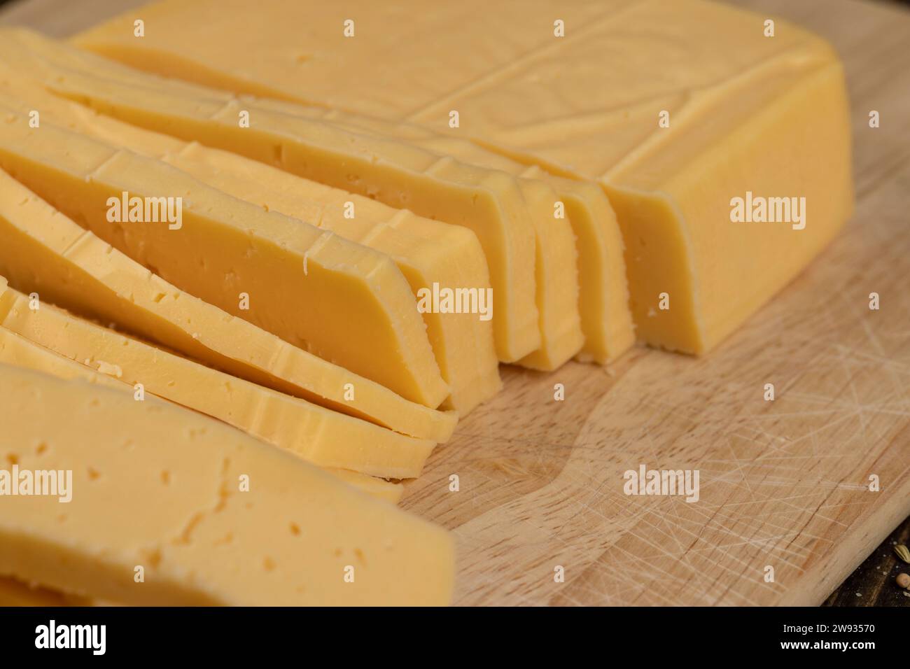 semi- hard cheese with holes cut into chunks , preparation of yellow ...