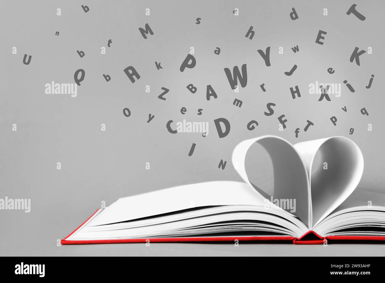 Letters flying out from open book on grey background, closeup Stock ...