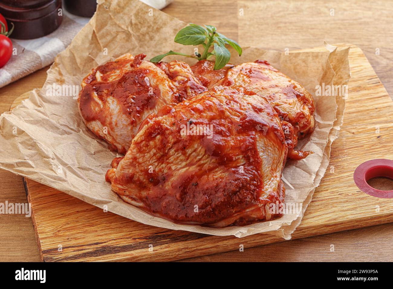 Marinated chicken leg thighs in tomato sauce Stock Photo - Alamy