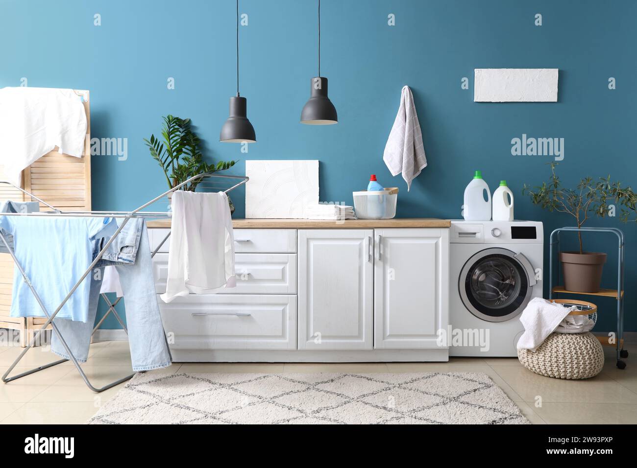 Laundry room interior with washing machine, white counters and clothes ...