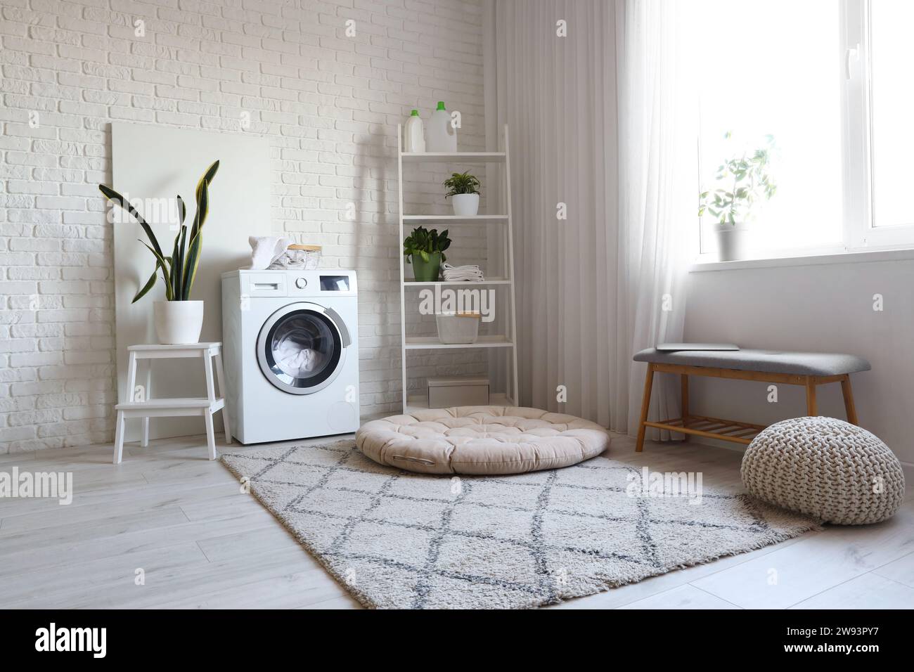 Interior of cozy laundry room with washing machine, shelving unit and ...