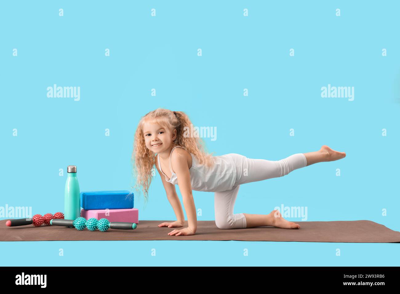 Cute little happy girl with body rollers, bottle of water and exercise ...