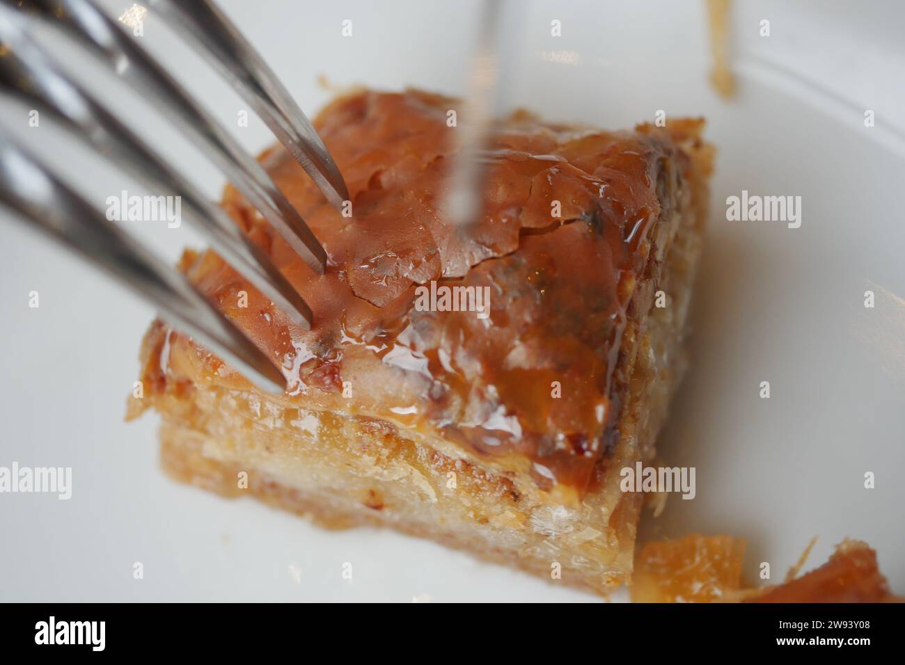 cutting turkish dessert baklava with knife and fork Stock Photo - Alamy