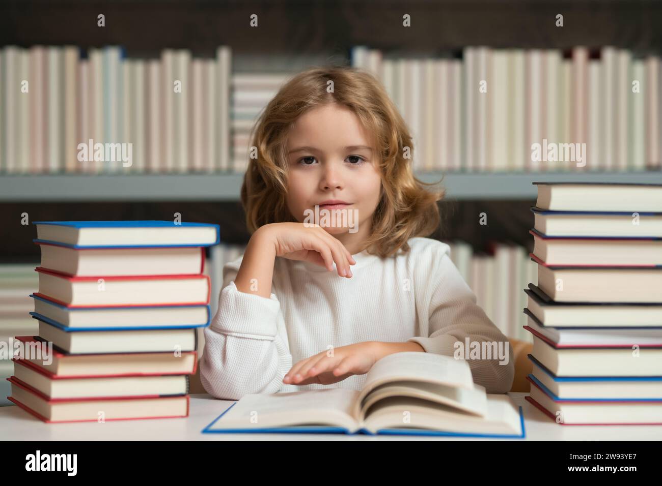 Back to school. Child reading book in a book store or school library ...