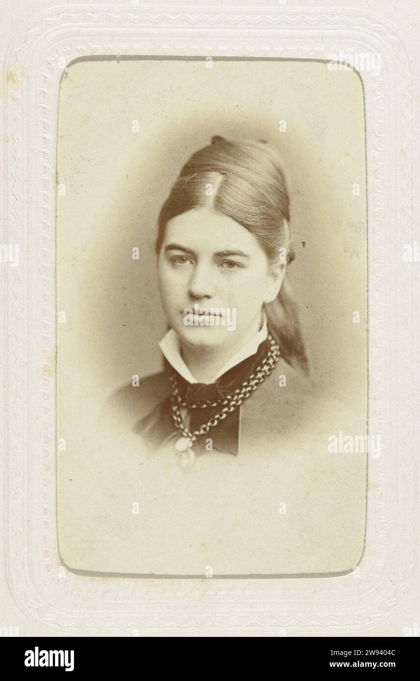 Studio portrait of a woman with a raised collar and a chain around her ...