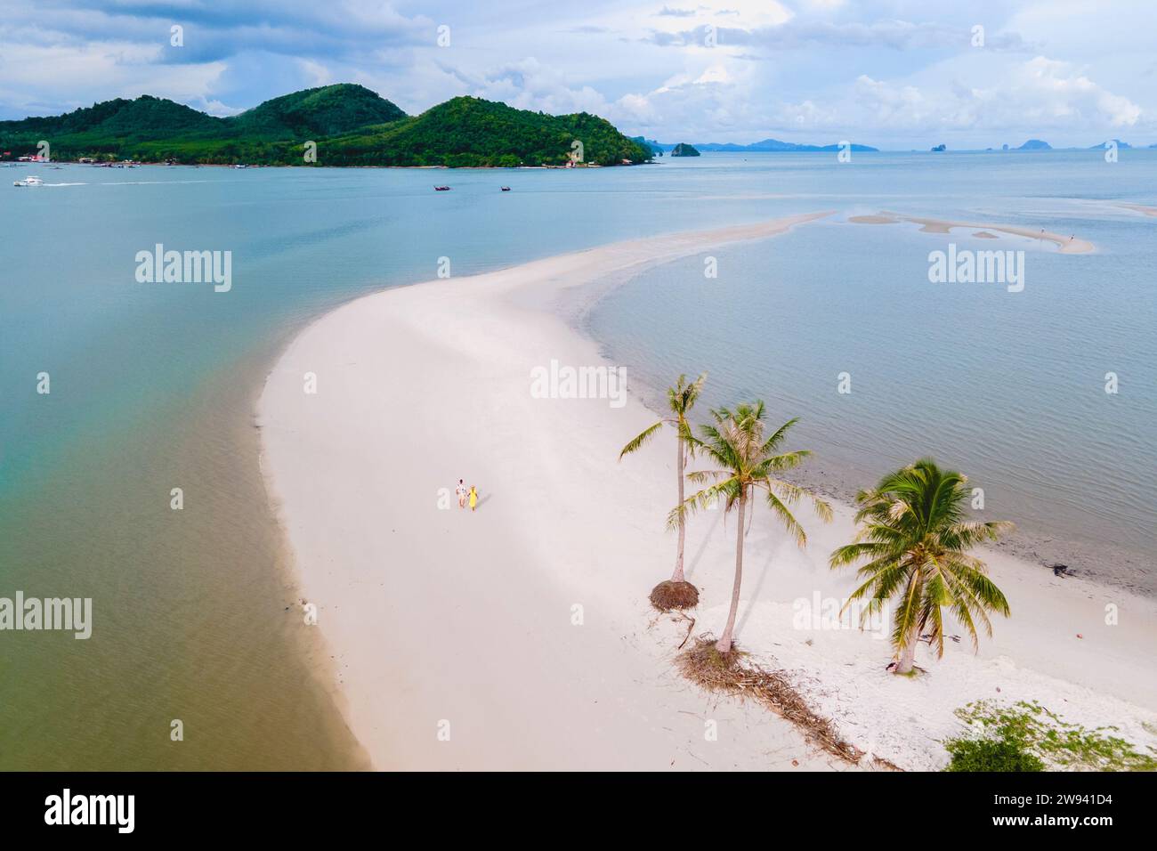 a couple of men and women walking on the beach at the Island Koh Yao ...