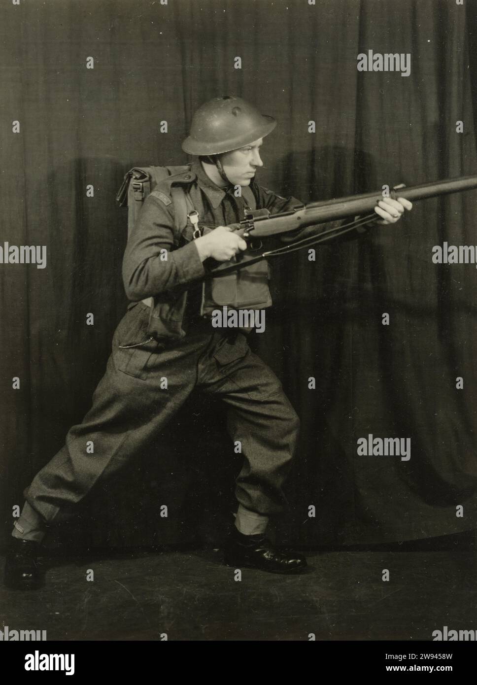 Military, 1940 - 1945 photograph A Dutch soldier poses for a curtain with a carbine in his hands ...