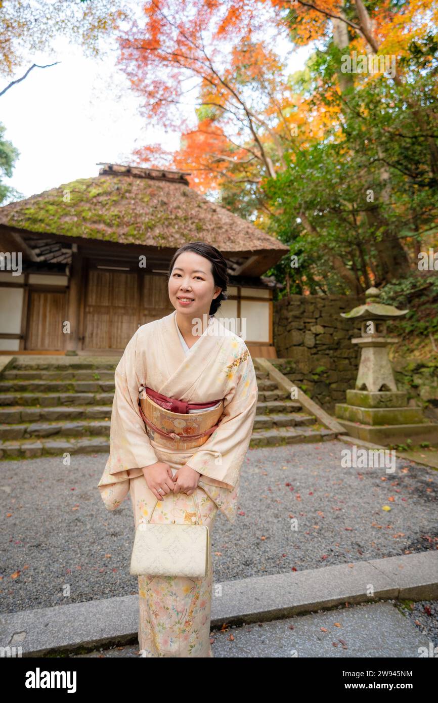Kyoto, Japan. Woman wearing kimono in Honen-in Temple fall foliage ...