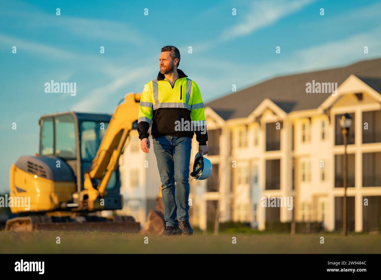 Man at construction site. Worker constructor in hardhat. Construction ...