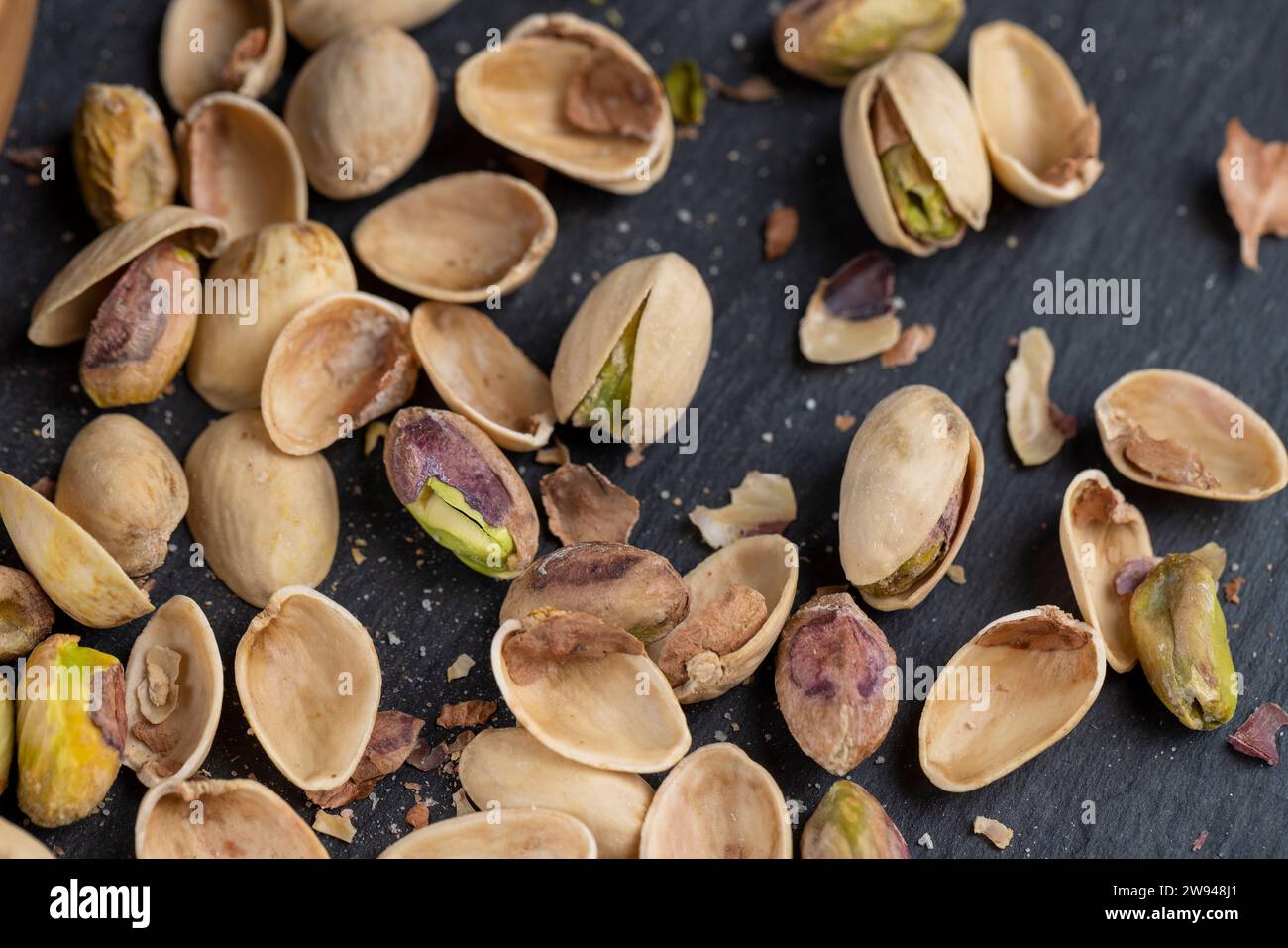salted pistachio nuts on the table, a large number of salty and crispy ...