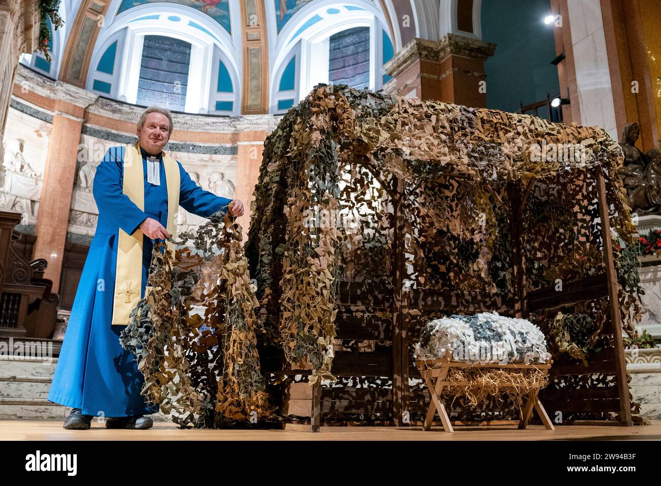 Parish minister Rev Peter Sutton stands alongside the nativity scene in ...