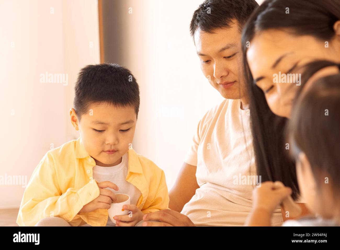 A happy Asian family. Korean parents and their cute little children ...
