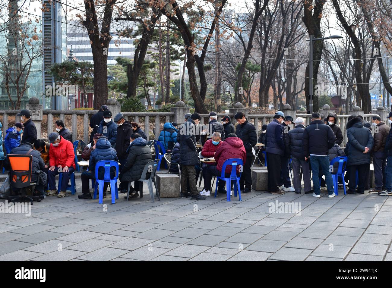 Groups of old men spectating other old men playing janggi, Korean chess ...
