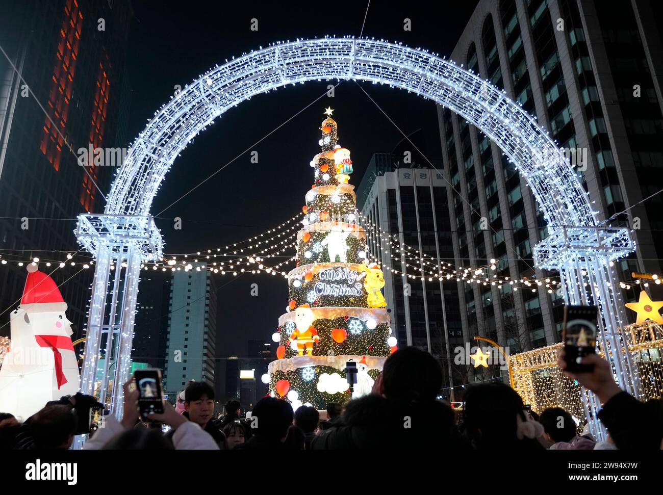 People gather around a Christmas tree over the Cheonggye stream on ...