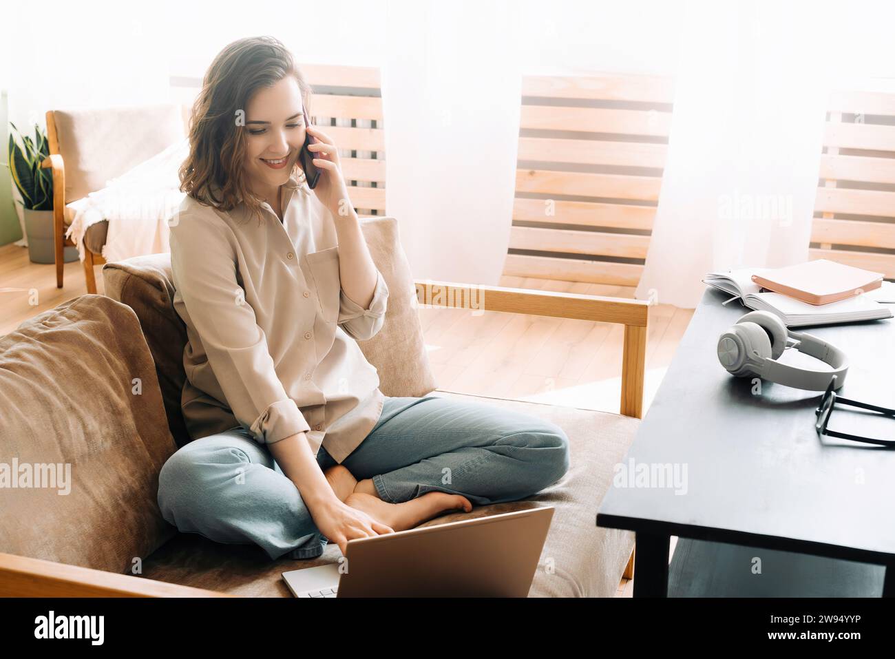 Multitasking in Style. Busy Young Woman on Sofa with Smartphone and ...