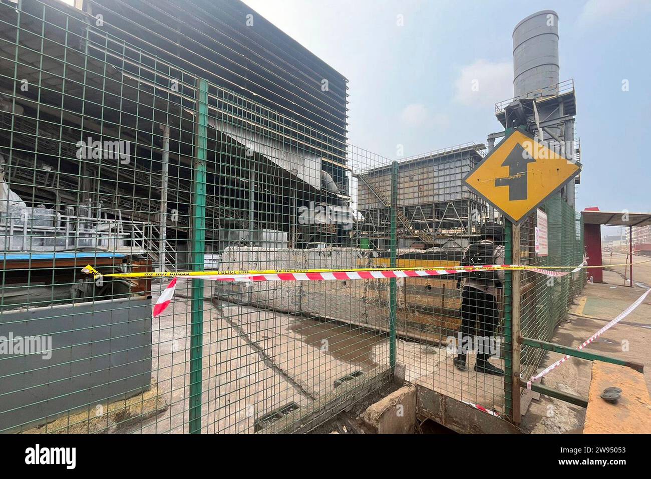 A police officer stands guard near the site where a furnace explosion ...