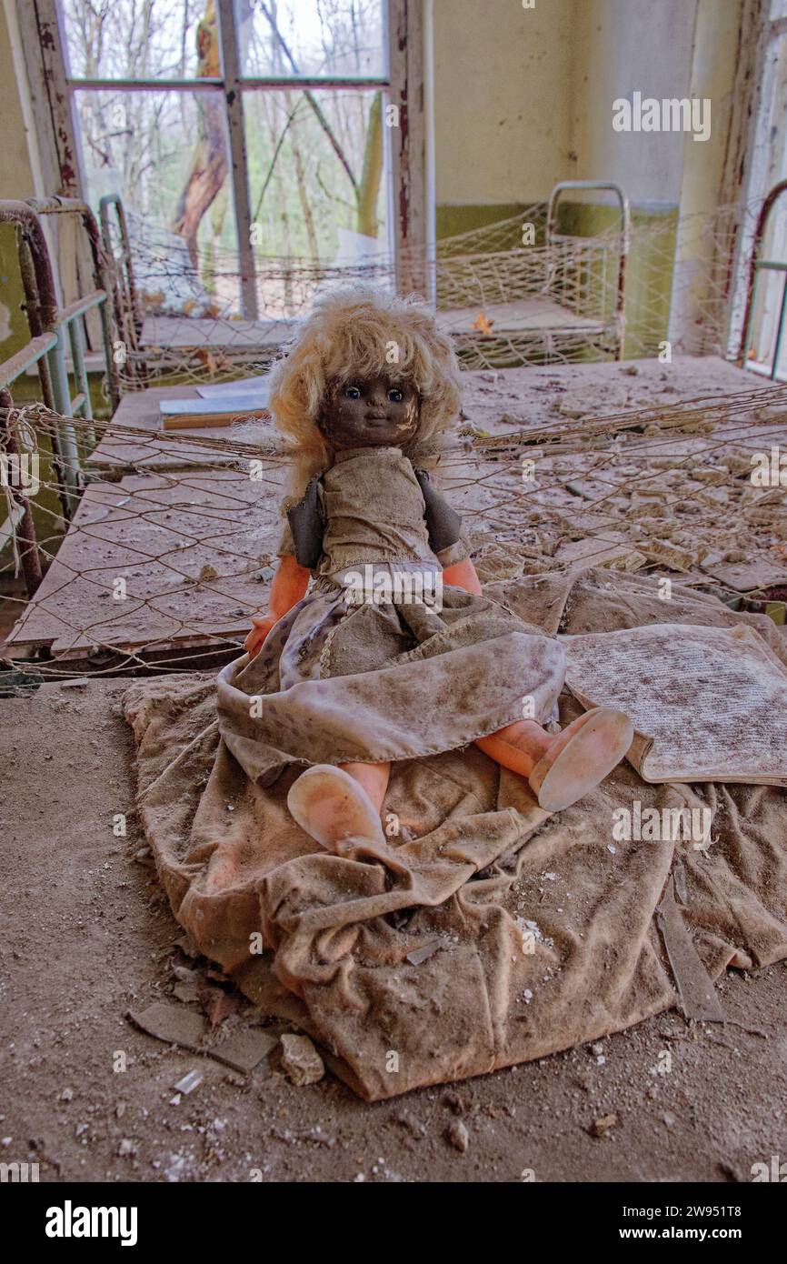 An abandoned room houses a doll with a sad expression. An old doll with ...