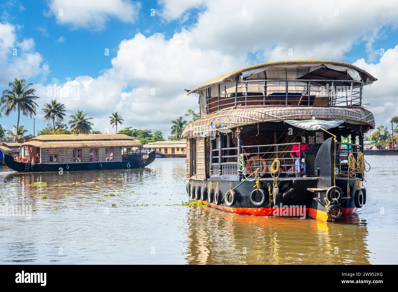 Indian traditional houseboats floating on Pamba river, with palms at ...