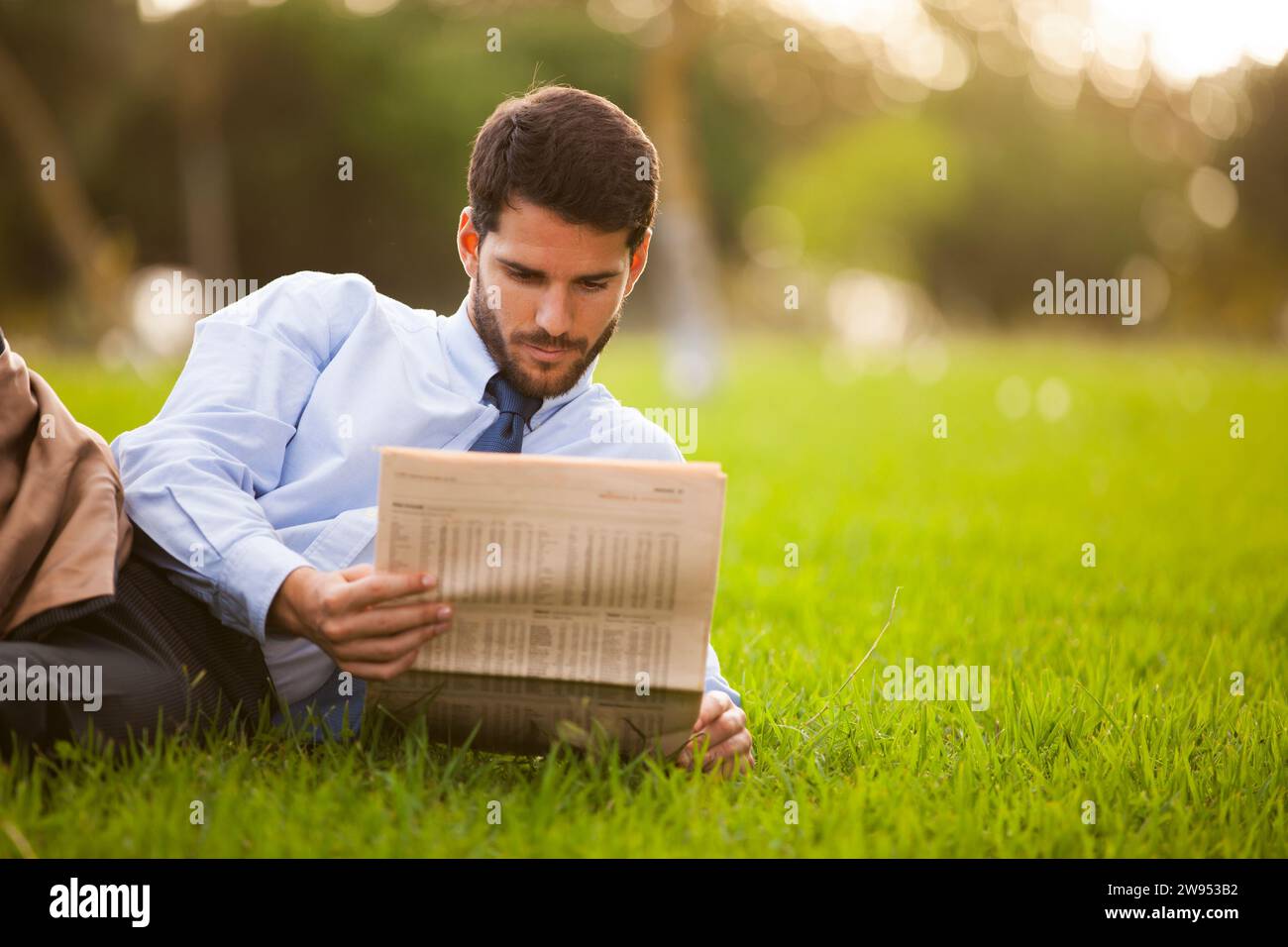 Businessman reading the newspaper Stock Photo - Alamy