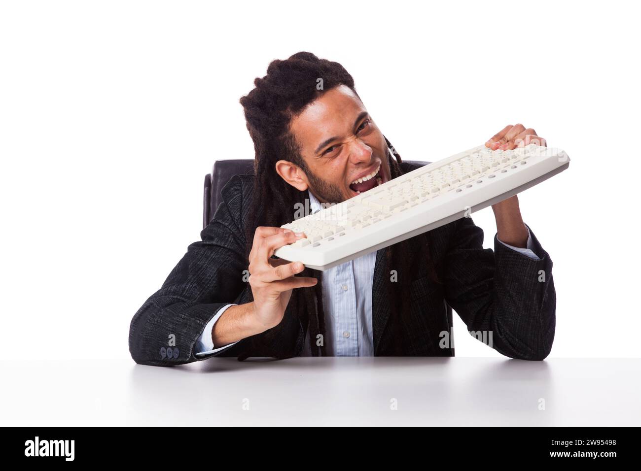 Furious rastafari man biting his keyboard Stock Photo - Alamy