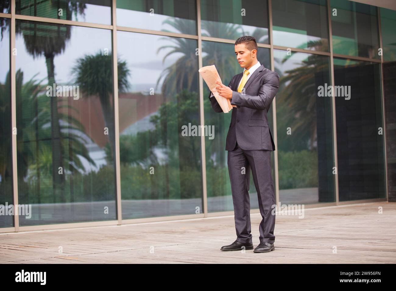 Businessman reading his newspaper next to his office building Stock ...