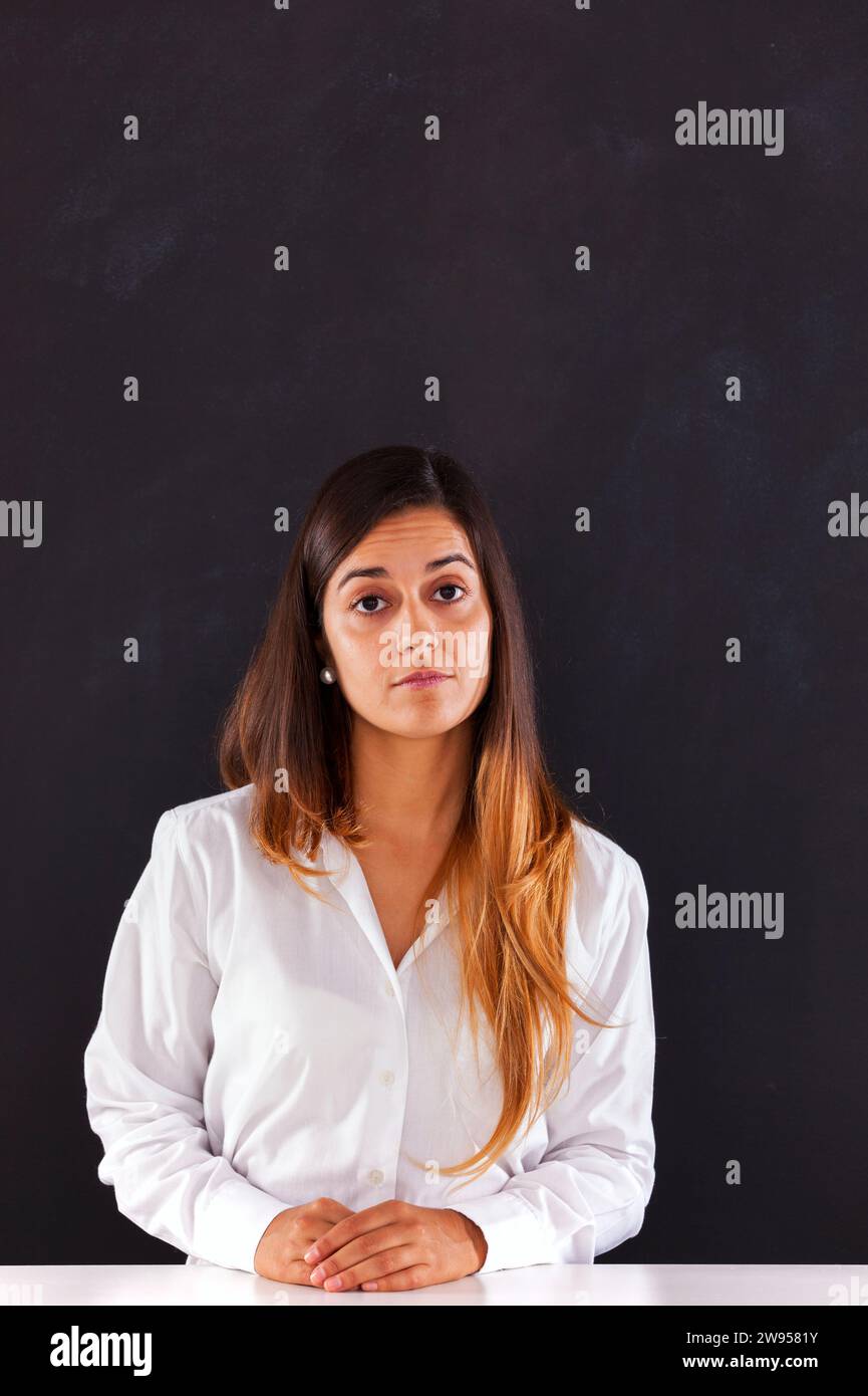 Woman thinking next to a blackboard Stock Photo - Alamy