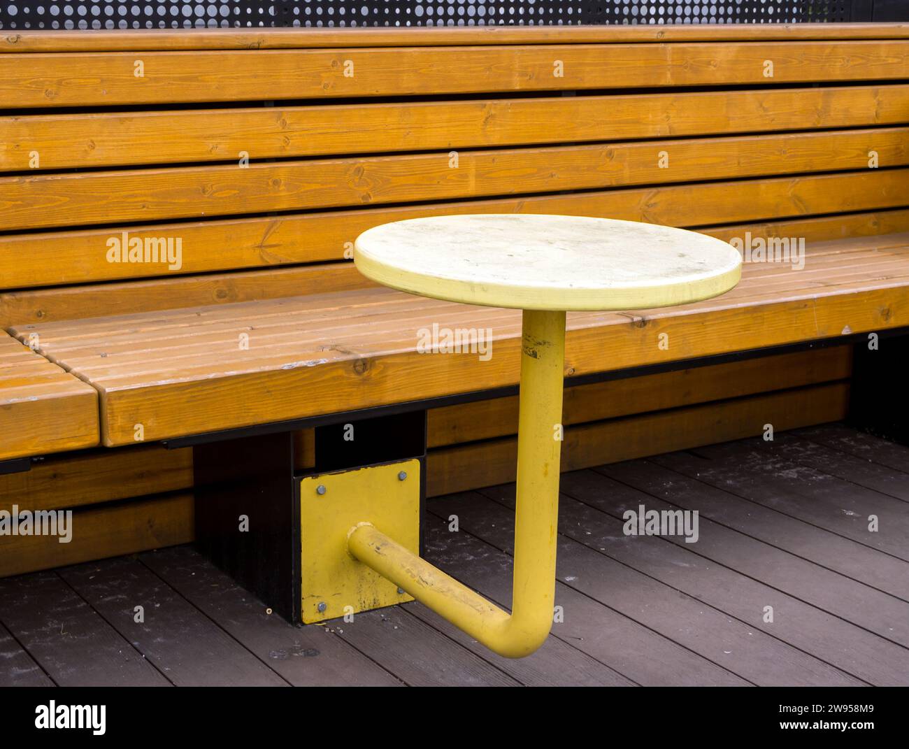 Round table attached to a bench on a corner support Stock Photo - Alamy