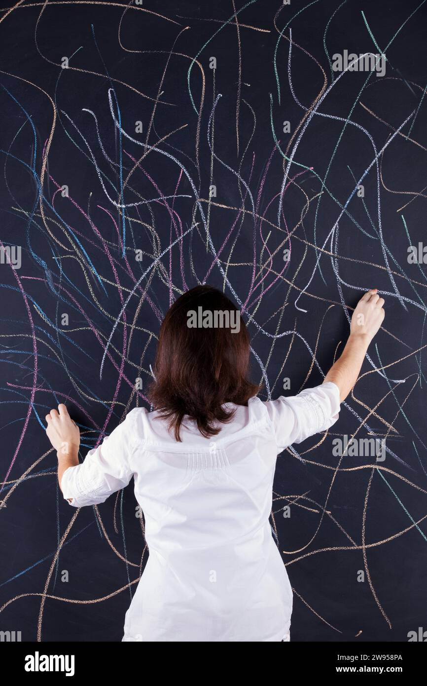 Stressed woman writing in the chalkboard lots of crazy lines Stock ...